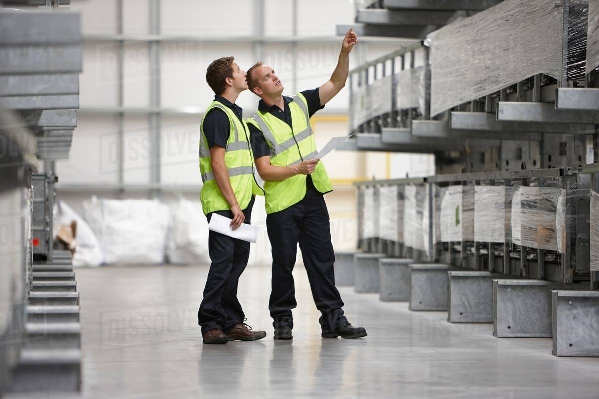 Warehouse workers checking shelves in engineering warehouse - Royalty ...