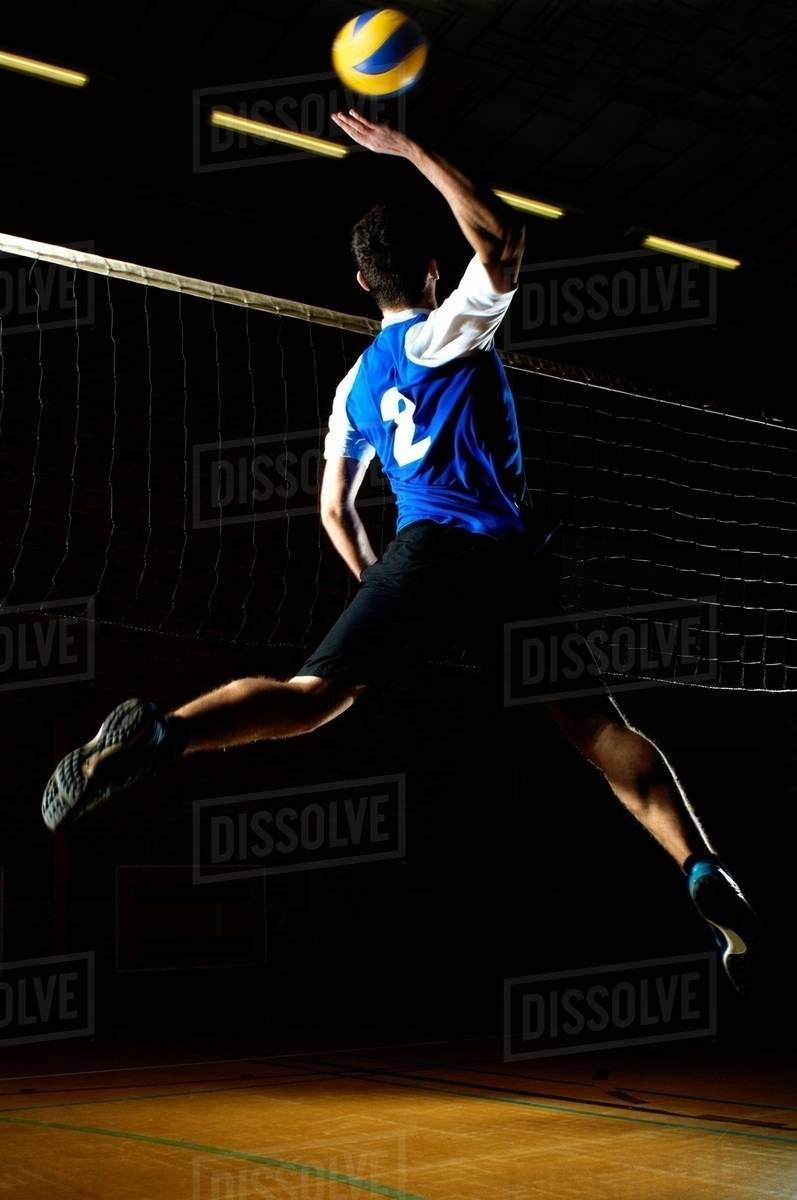 Volleyball player jumping for ball by net - Royalty-free Stock Photo ...