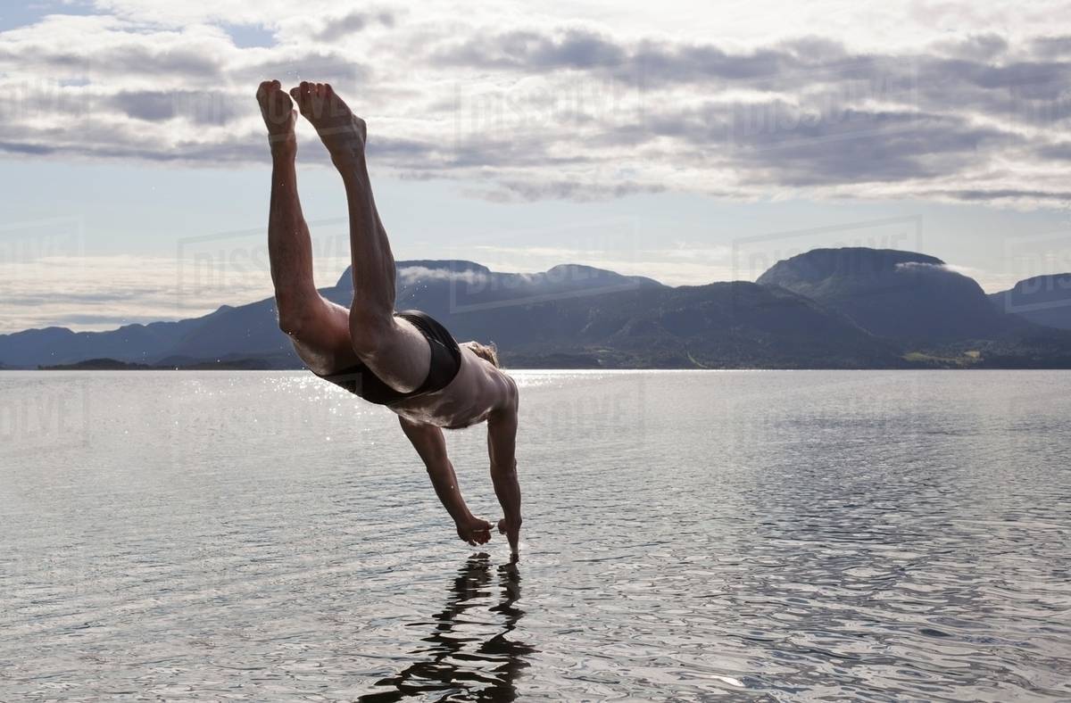 Man diving into water, Aure, Norway - Royalty-free Stock Photo | Dissolve