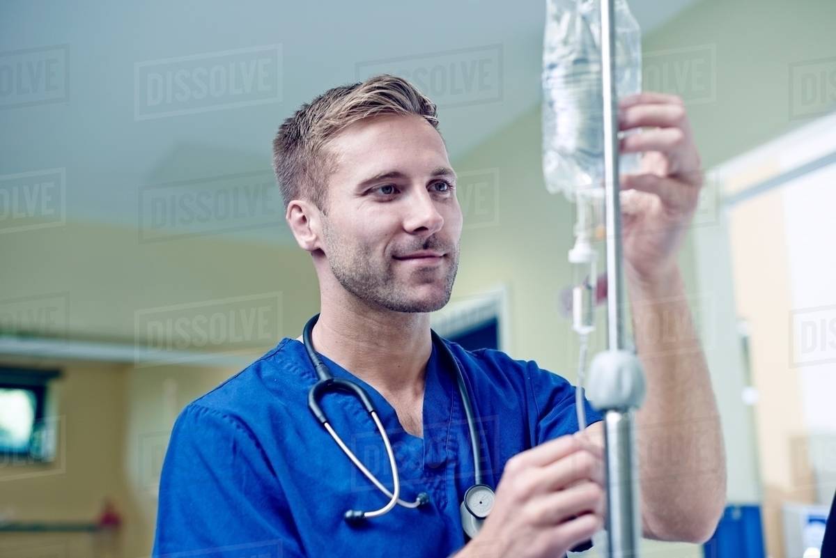 Doctor checking intravenous drip in hospital - Stock Photo - Dissolve