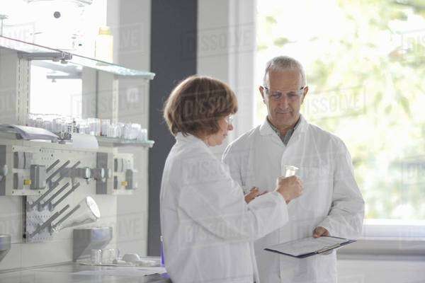 Scientists working in laboratory, holding vial - Royalty-free Stock ...