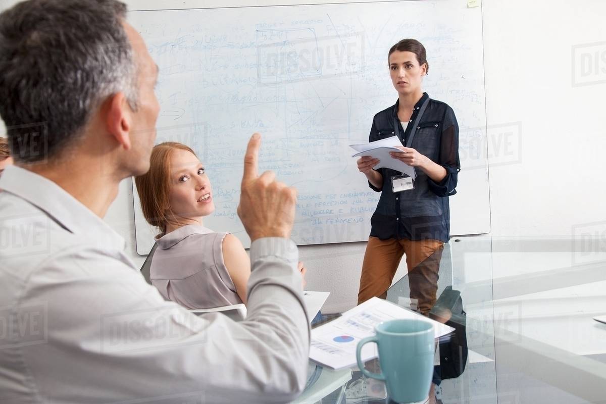 Businesswoman presenting to colleagues - Stock Photo - Dissolve