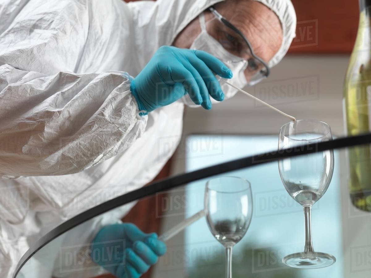 Forensic scientist using a DNA swab to take evidence from a glass at a ...