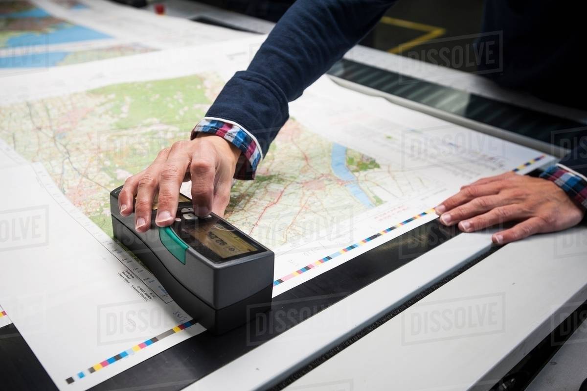 Worker checking print quality of products in print workshop - Stock ...