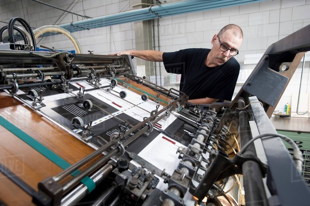 Worker monitoring print machine in printing workshop - Stock Photo ...