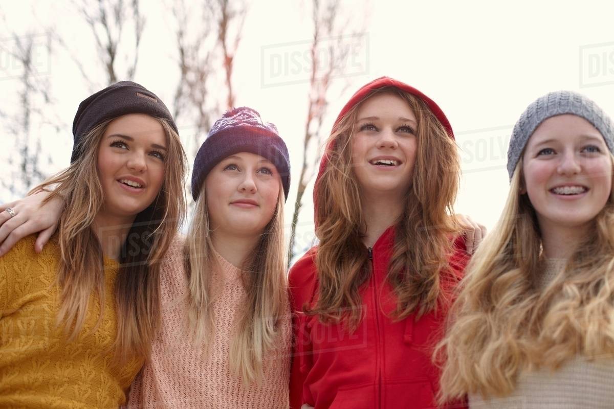Portrait of four teenage girls in hats - Stock Photo - Dissolve