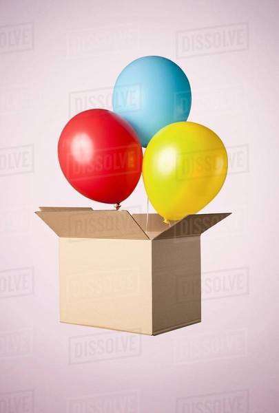 Studio shot of cardboard box with balloons coming out - Royalty-free ...