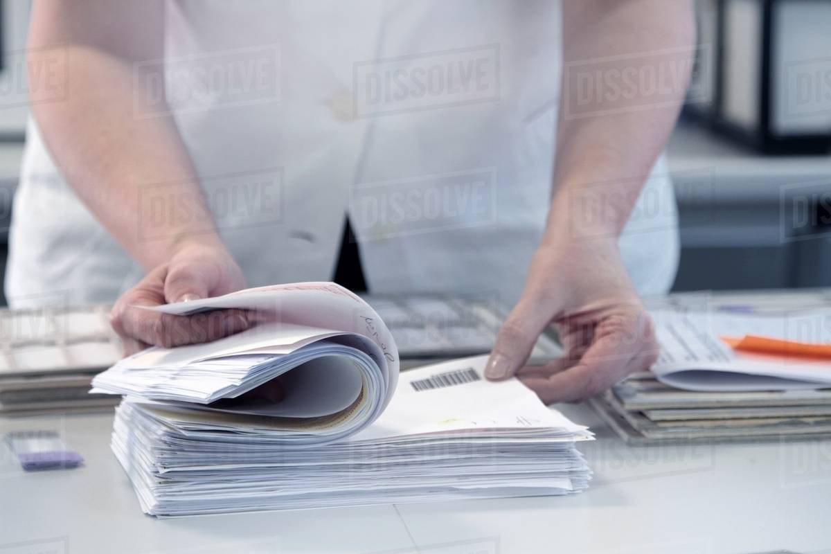Female scientist checking through paperwork - Royalty-free Stock Photo ...