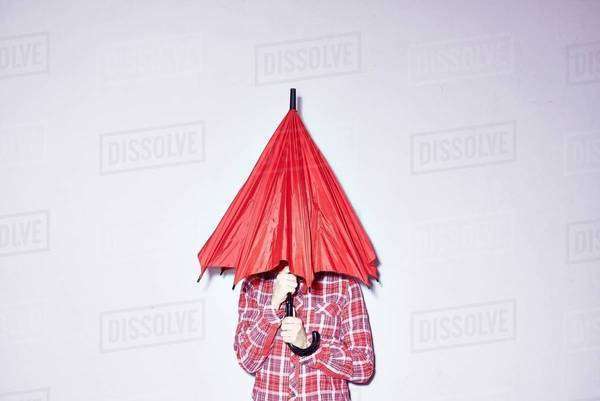 Studio shot of young woman holding red umbrella over her head - Royalty ...