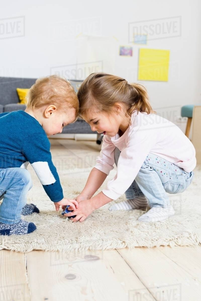 Brother and sister playing at home - Stock Photo - Dissolve