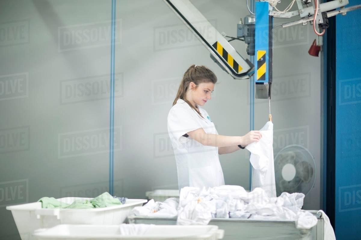 Woman working in laundry - Stock Photo - Dissolve