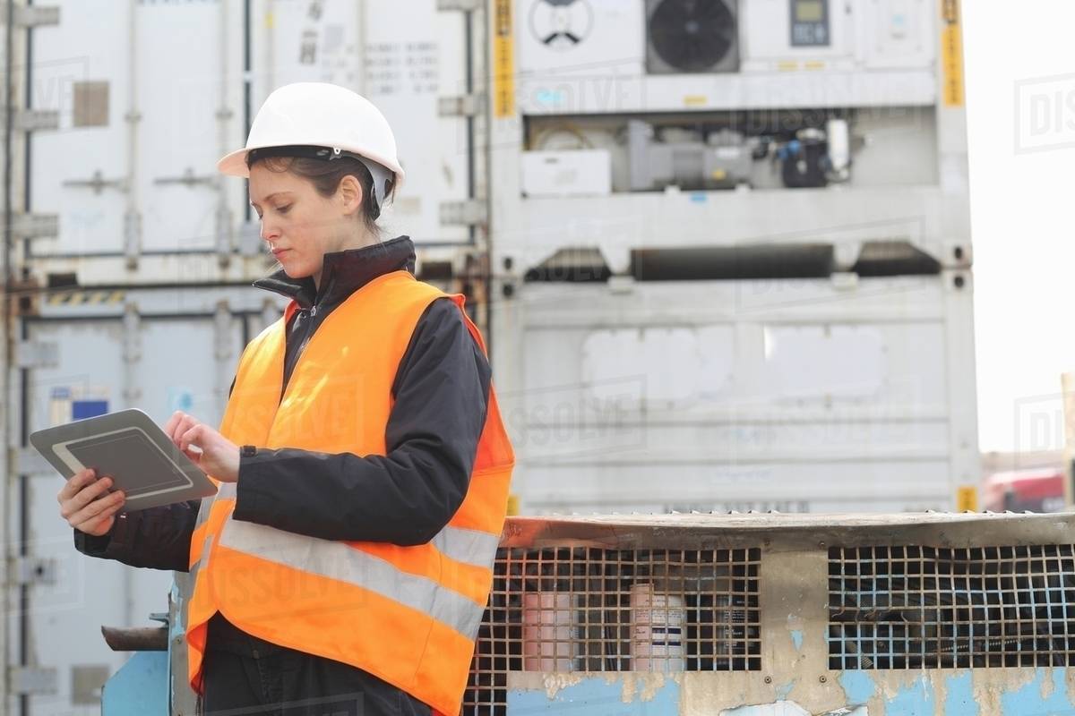 Female dockworker using monitor - Stock Photo - Dissolve