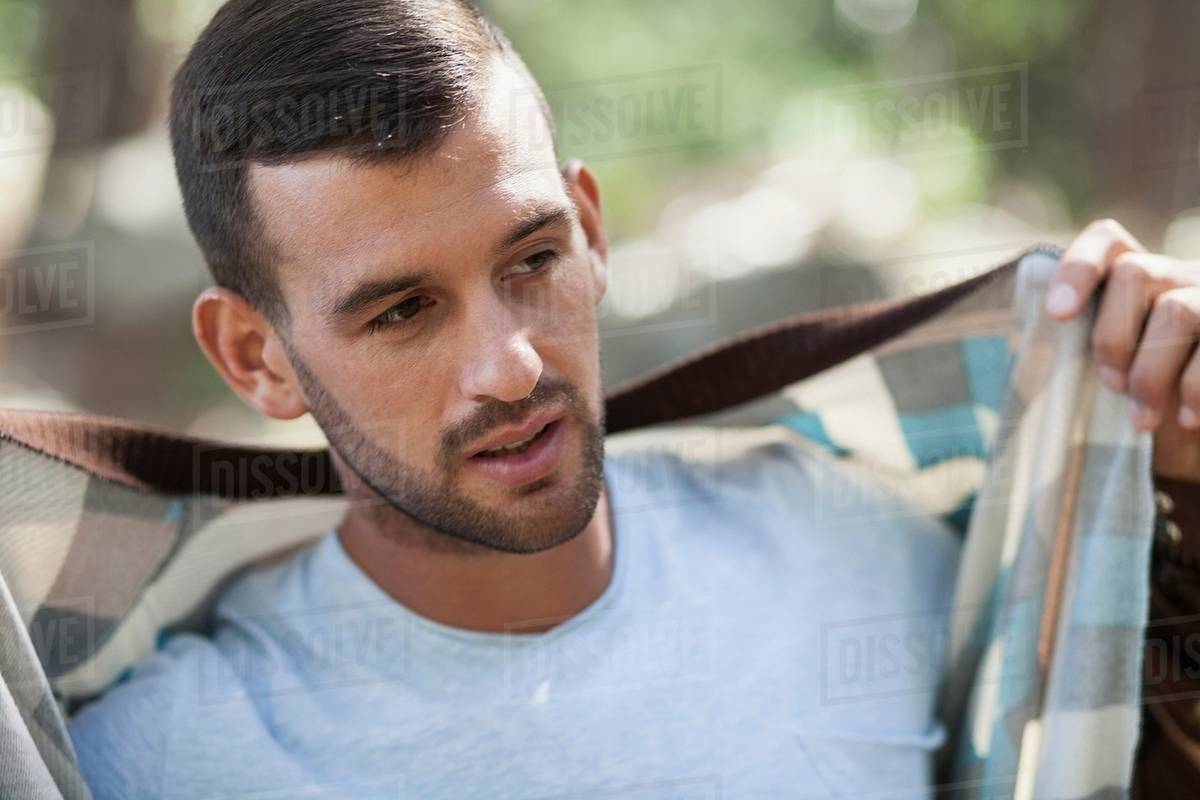 Portrait of young man putting on jacket - Royalty-free Stock Photo ...