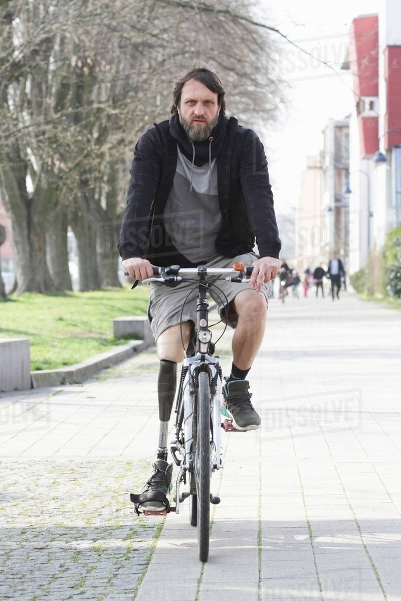 Portrait of man with prosthesis leg cycling - Stock Photo - Dissolve
