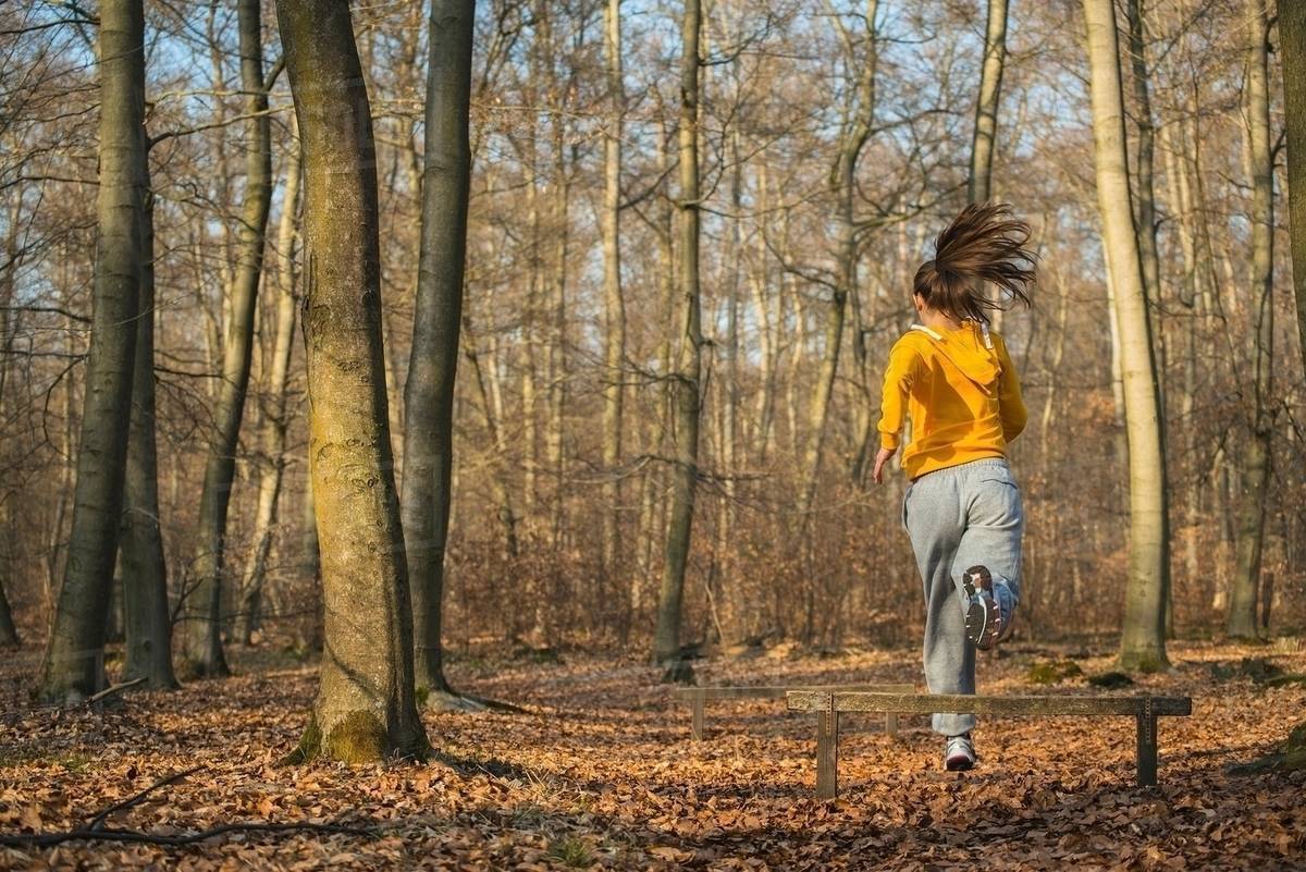 Young woman jumping fence on assault course in forest - Royalty-free ...