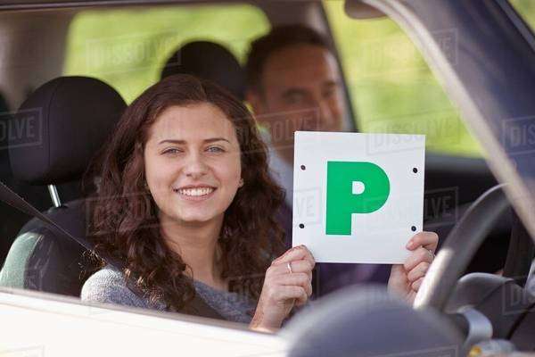 Female learner driver holding Passed Plate - Stock Photo - Dissolve