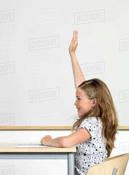 Girl raising hand in classroom - Royalty-free Stock Photo | Dissolve