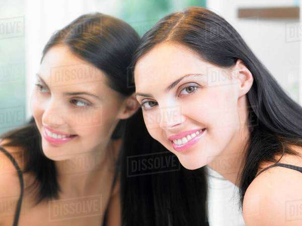 Woman's reflection in the mirror - Stock Photo - Dissolve