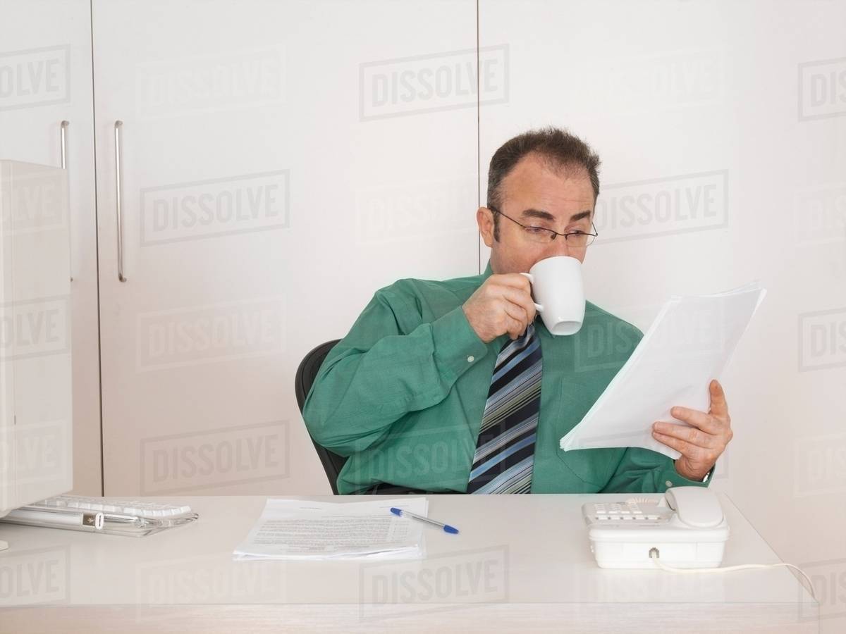 Businessman looking at papers - Stock Photo - Dissolve