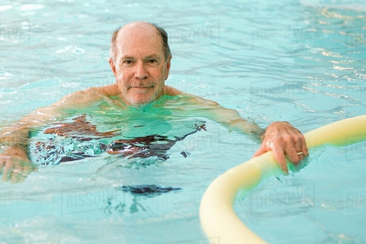 Older man swimming in pool - Stock Photo - Dissolve