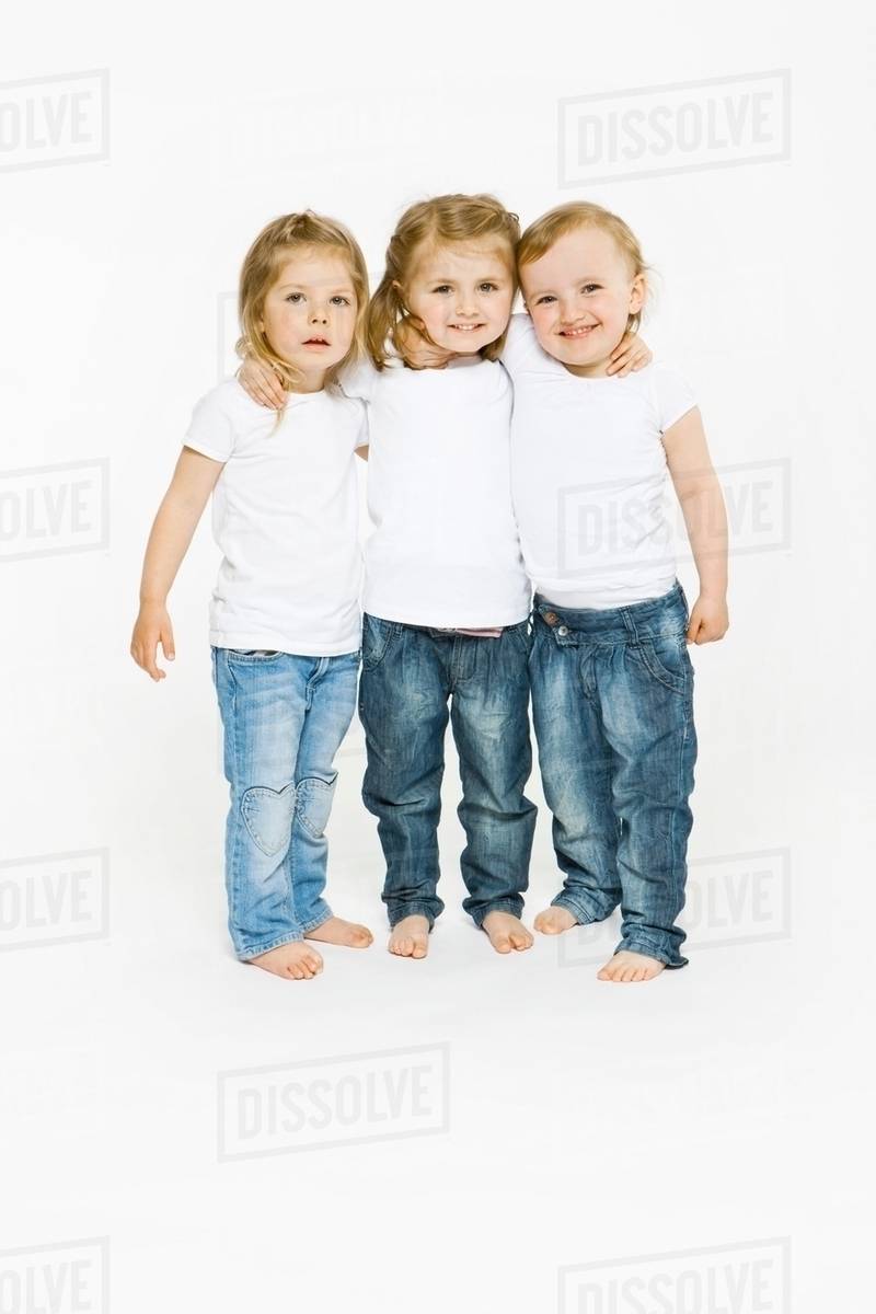 Three toddler girls hugging - Stock Photo - Dissolve