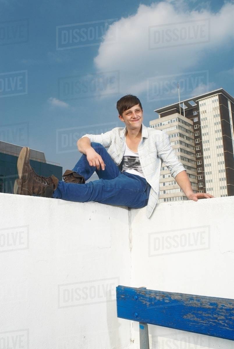 Man sitting on urban rooftop - Royalty-free Stock Photo | Dissolve