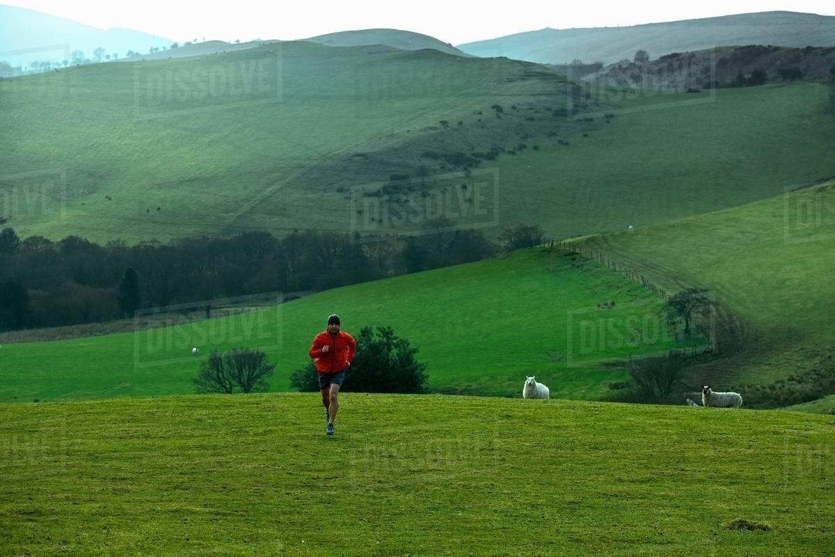 Man running in rural hills - Royalty-free Stock Photo | Dissolve