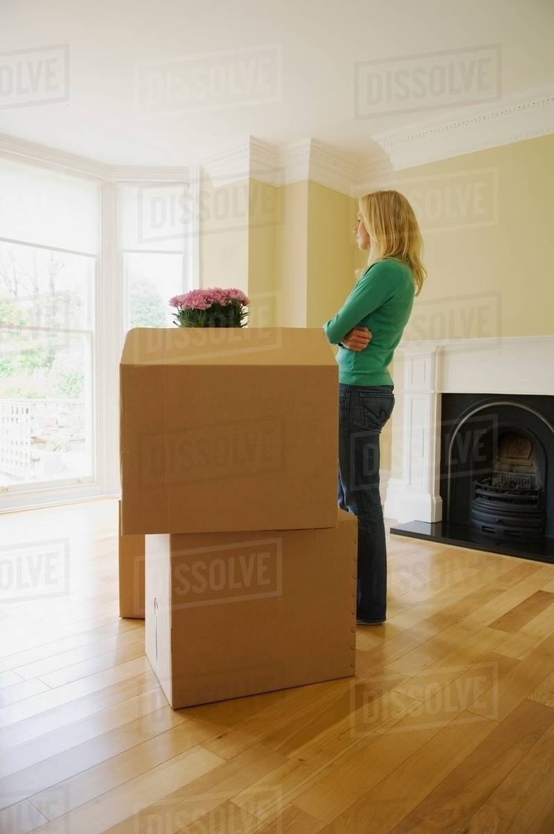 Woman with cardboard boxes in new home - Stock Photo - Dissolve