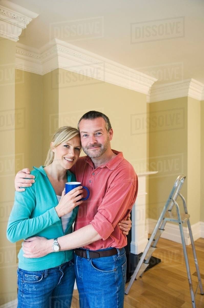Smiling couple hugging in new home - Stock Photo - Dissolve