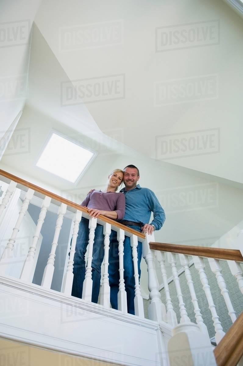 Smiling couple standing on stairs - Royalty-free Stock Photo | Dissolve