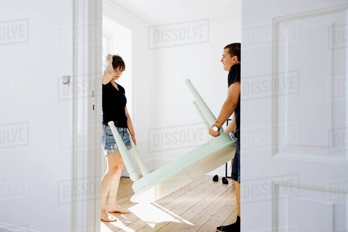 Couple carrying table in new home - Royalty-free Stock Photo | Dissolve