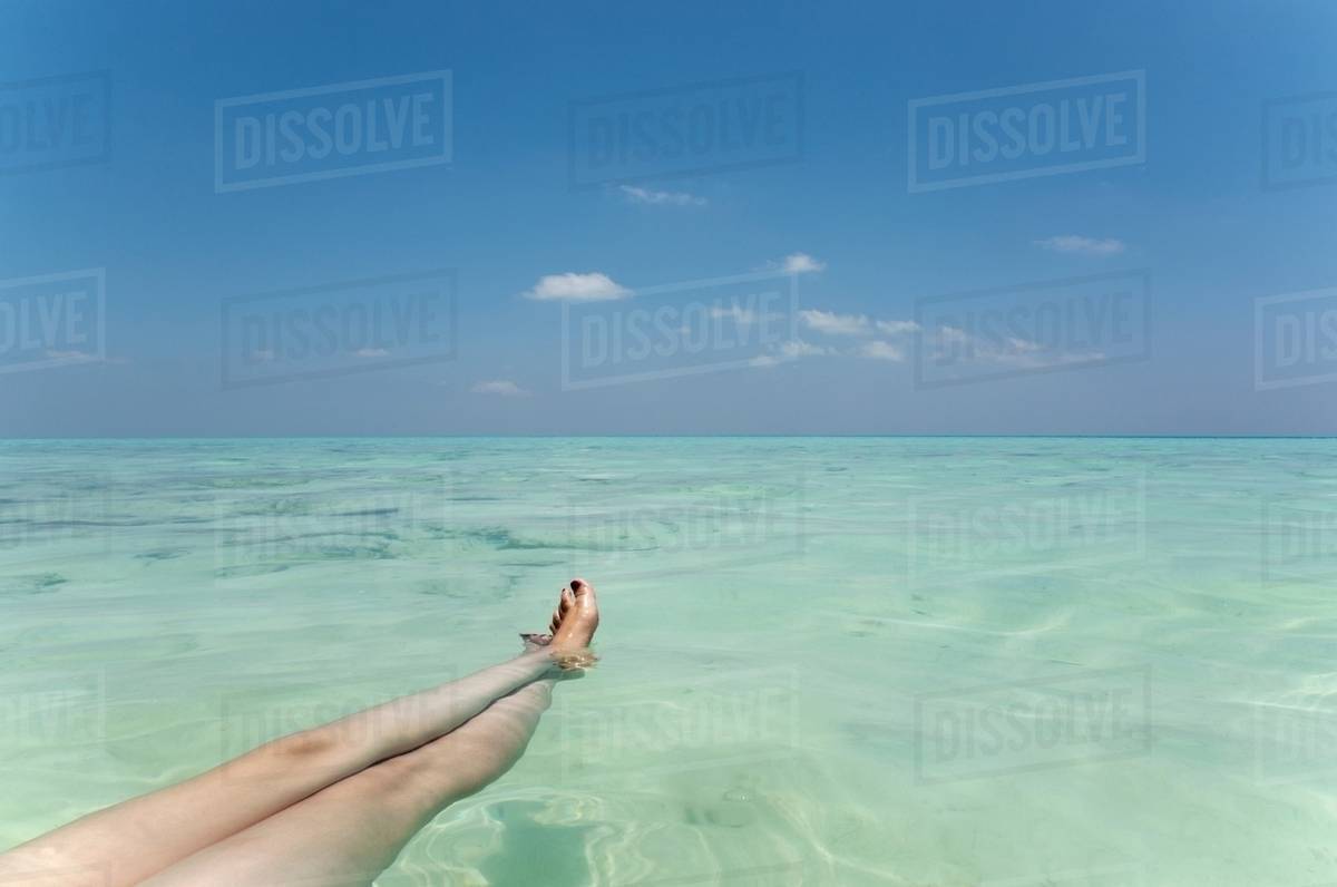 Woman's legs floating in tropical sea - Royalty-free Stock Photo | Dissolve