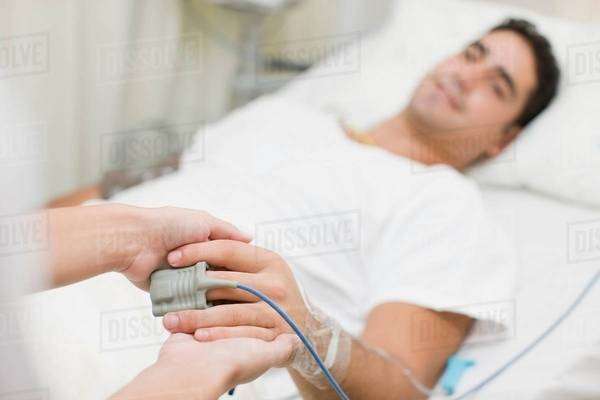 Person holding hospital patient's hand - Stock Photo - Dissolve