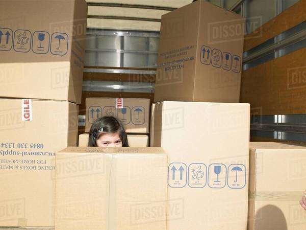 Girl hiding in boxes in moving van - Stock Photo - Dissolve