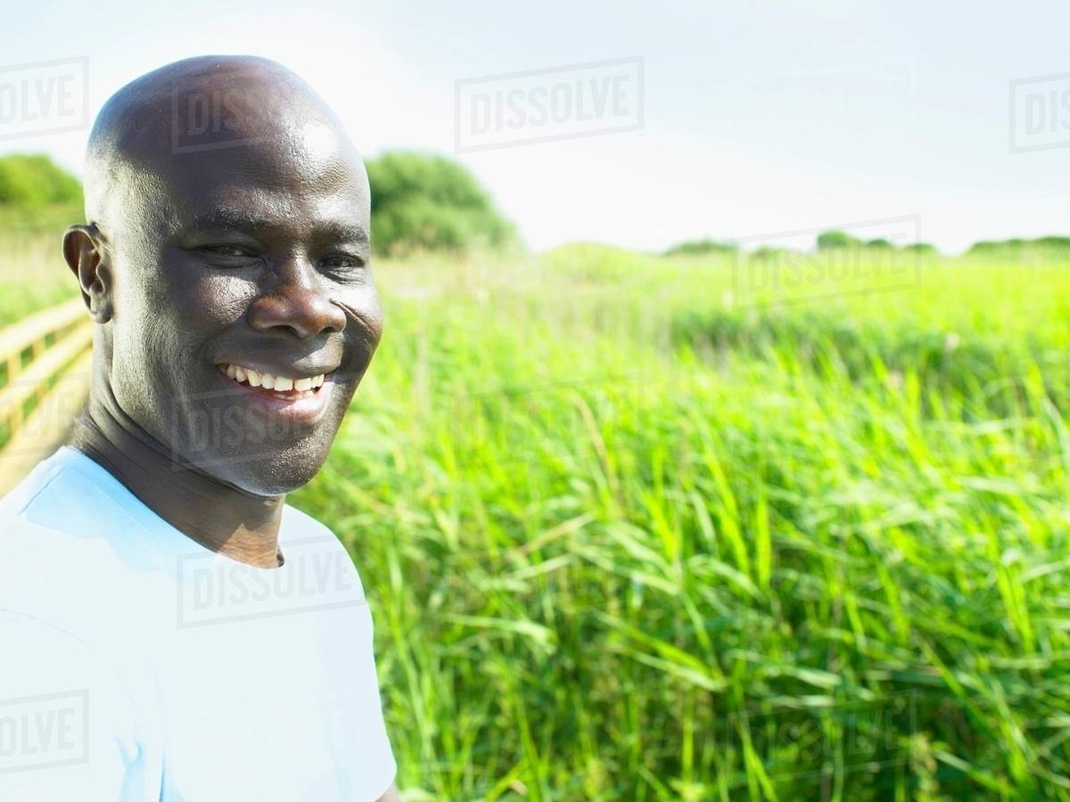 Man smiling in field of flowers - Royalty-free Stock Photo | Dissolve