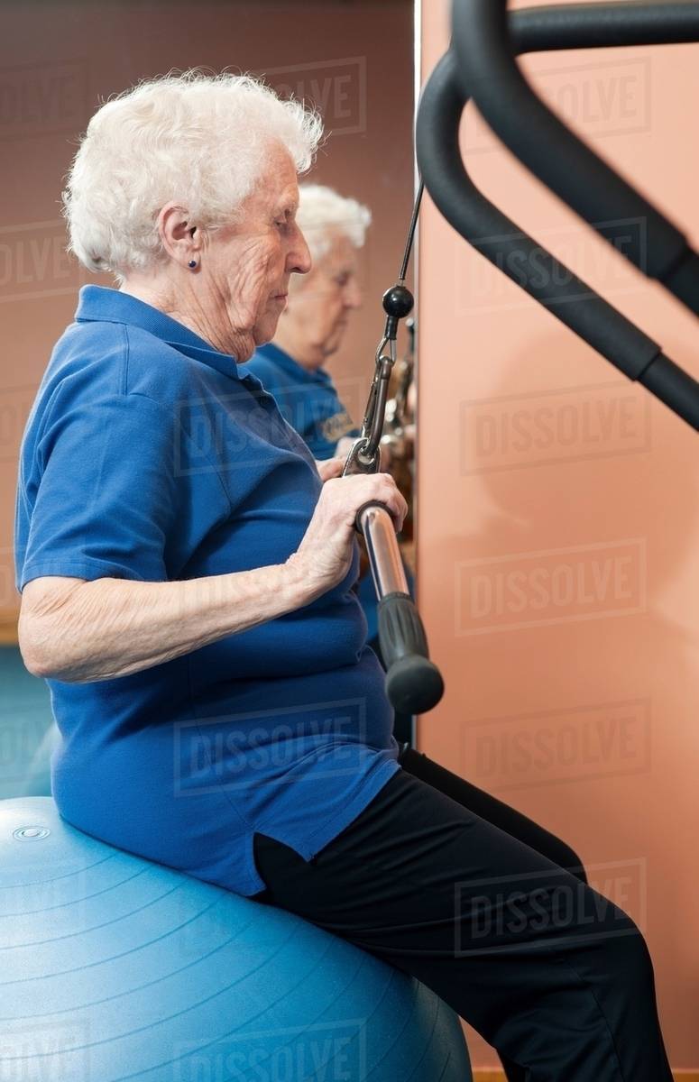 Older woman using exercise machine - Royalty-free Stock Photo | Dissolve