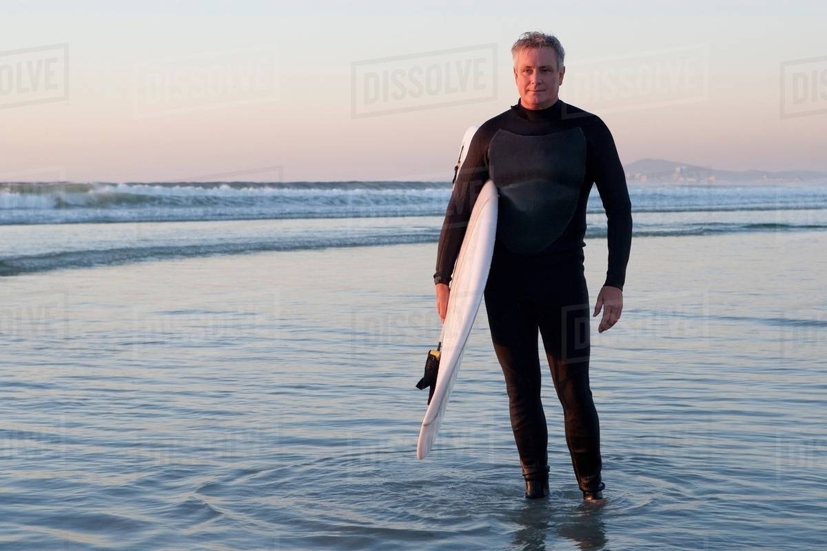 Surfer standing in water - Royalty-free Stock Photo | Dissolve