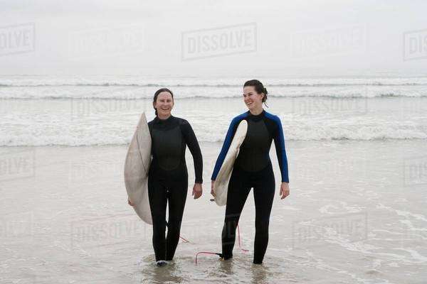Surfers walking in water - Royalty-free Stock Photo | Dissolve