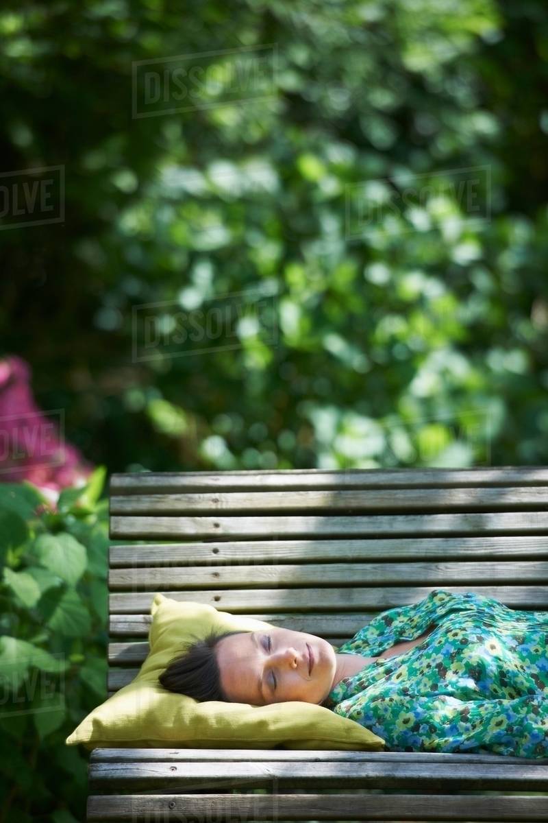Woman relaxing on park bench - Stock Photo - Dissolve
