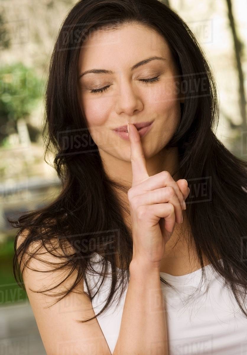 Woman holding finger to her lips - Royalty-free Stock Photo | Dissolve