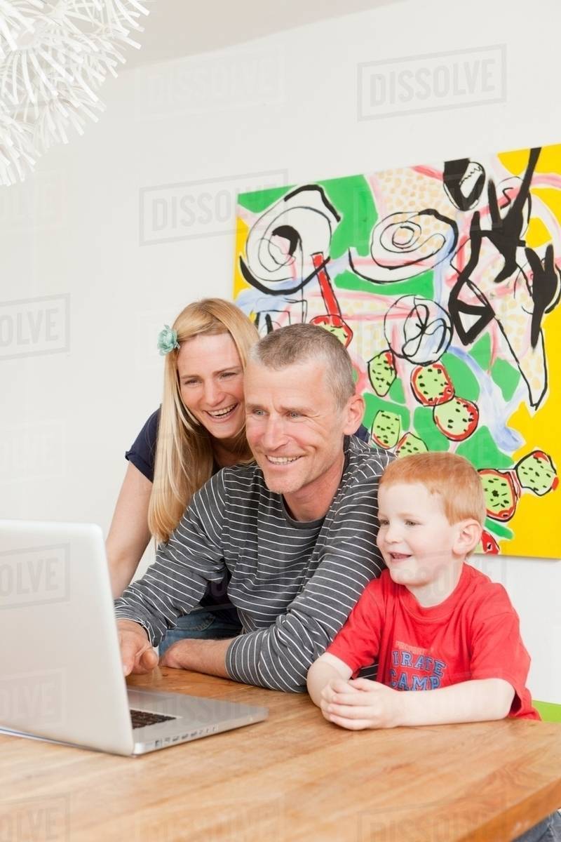 Family using laptop together - Royalty-free Stock Photo | Dissolve