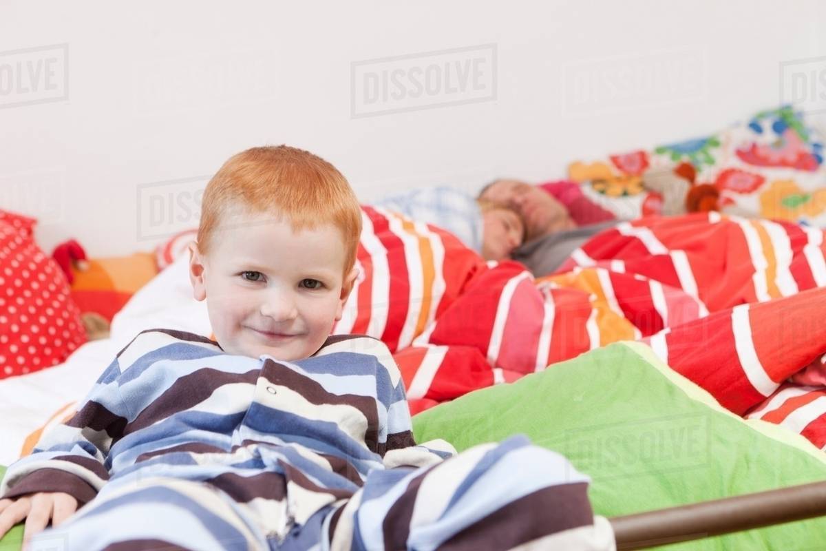 Boy sneaking into sleeping parents' bed - Royalty-free Stock Photo ...