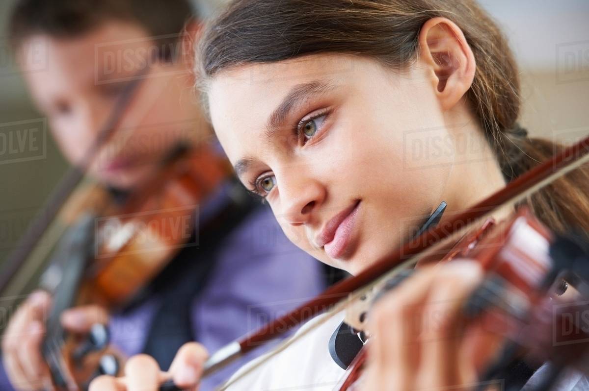 Serious children playing violin - Stock Photo - Dissolve