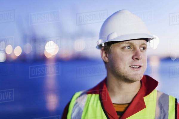 Worker wearing hard hat in shipyard - Royalty-free Stock Photo | Dissolve