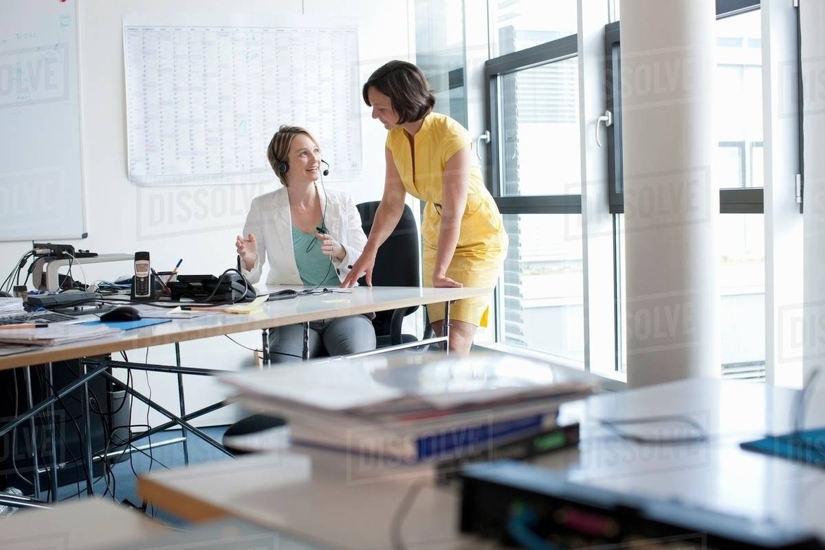 Businesswomen talking in office - Stock Photo - Dissolve