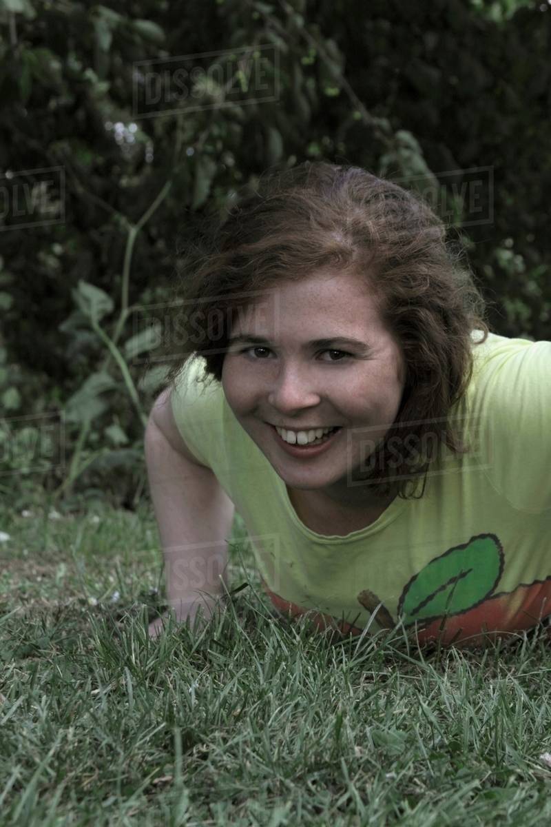 Girl laying in grass at park - Royalty-free Stock Photo | Dissolve