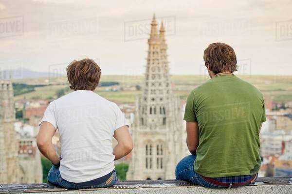 Men on wall overlooking urban cityscape - Royalty-free Stock Photo ...