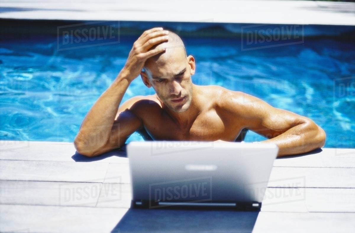 Man using laptop in swimming pool - Royalty-free Stock Photo | Dissolve