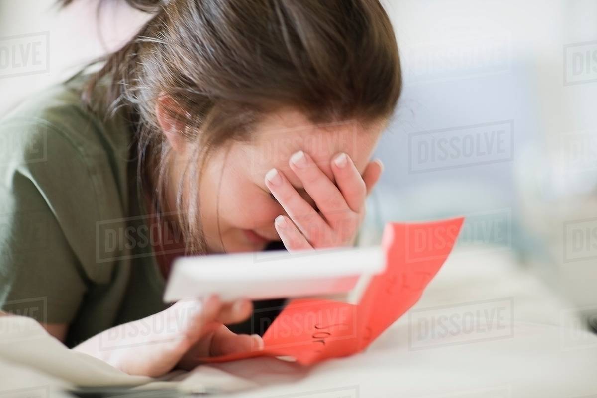 Crying teenage girl reading letter - Royalty-free Stock Photo | Dissolve