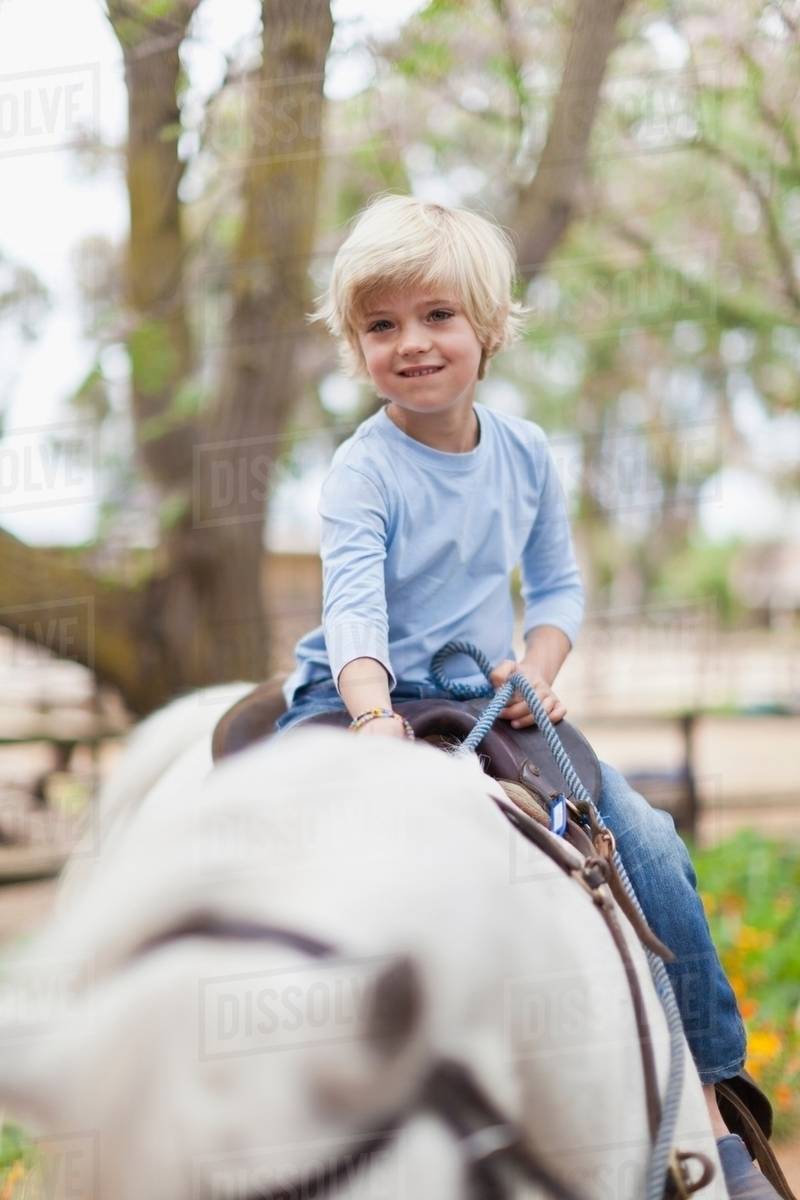 Smiling boy riding horse - Royalty-free Stock Photo | Dissolve